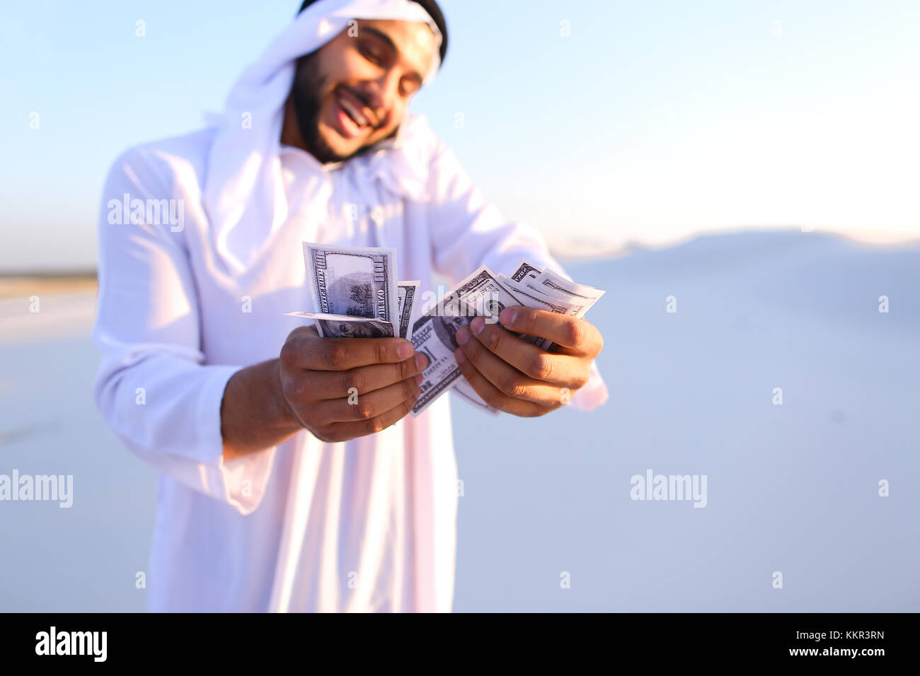 Arab young sheikh calls to friend or business partner and with smile on ...