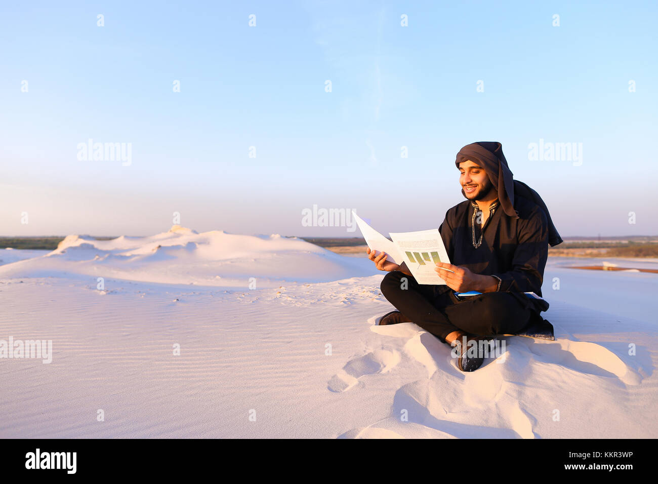 Educated male Muslim builder or designer works with drawings and ...