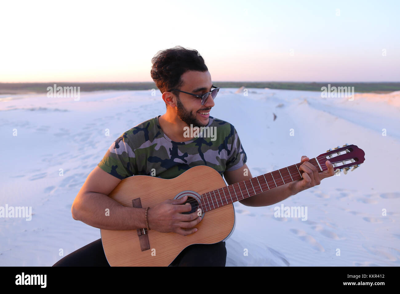 Handsome guy, Arab playing with pleasure on musical stringed instrument ...