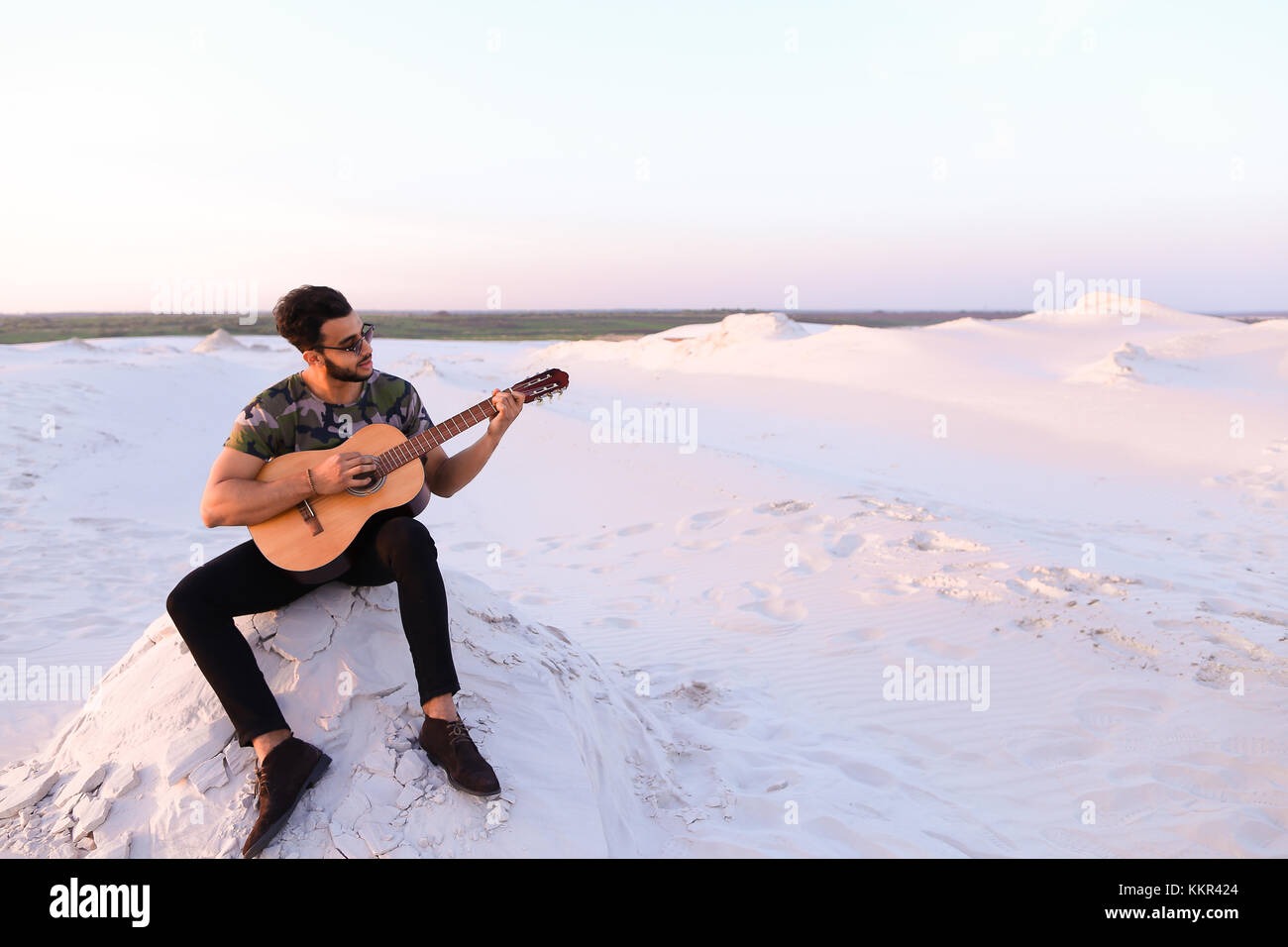 Handsome guy, Arab playing with pleasure on musical stringed instrument ...