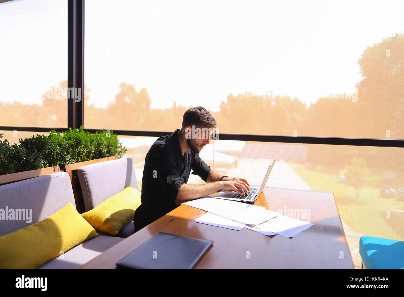 Freelance copywriter typing text fast on laptop keyboard at cafe table ...