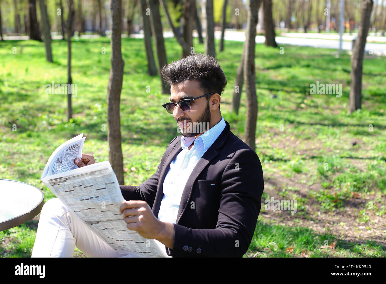 Business person reading newspaper and smiling with dimples on face ...
