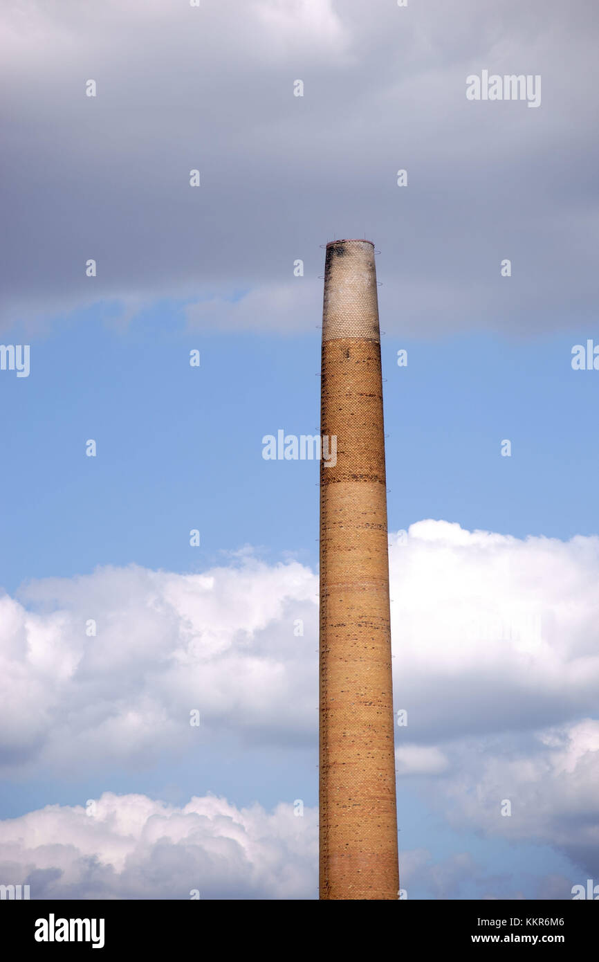 A high industrial chimney of a power station in front of the clouds ...