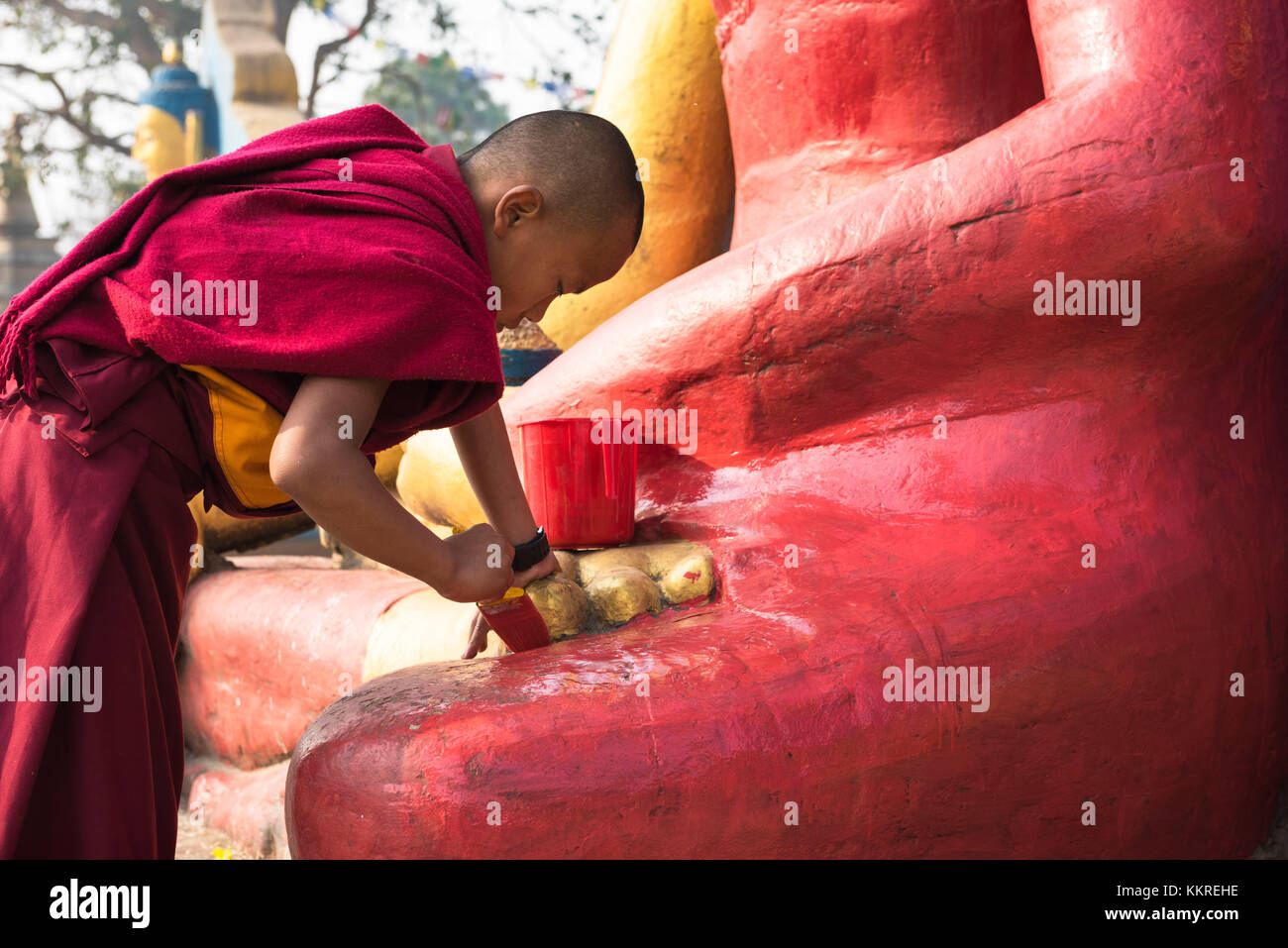 Nepal young monk painting the statue at swayambhunath temple hi-res ...