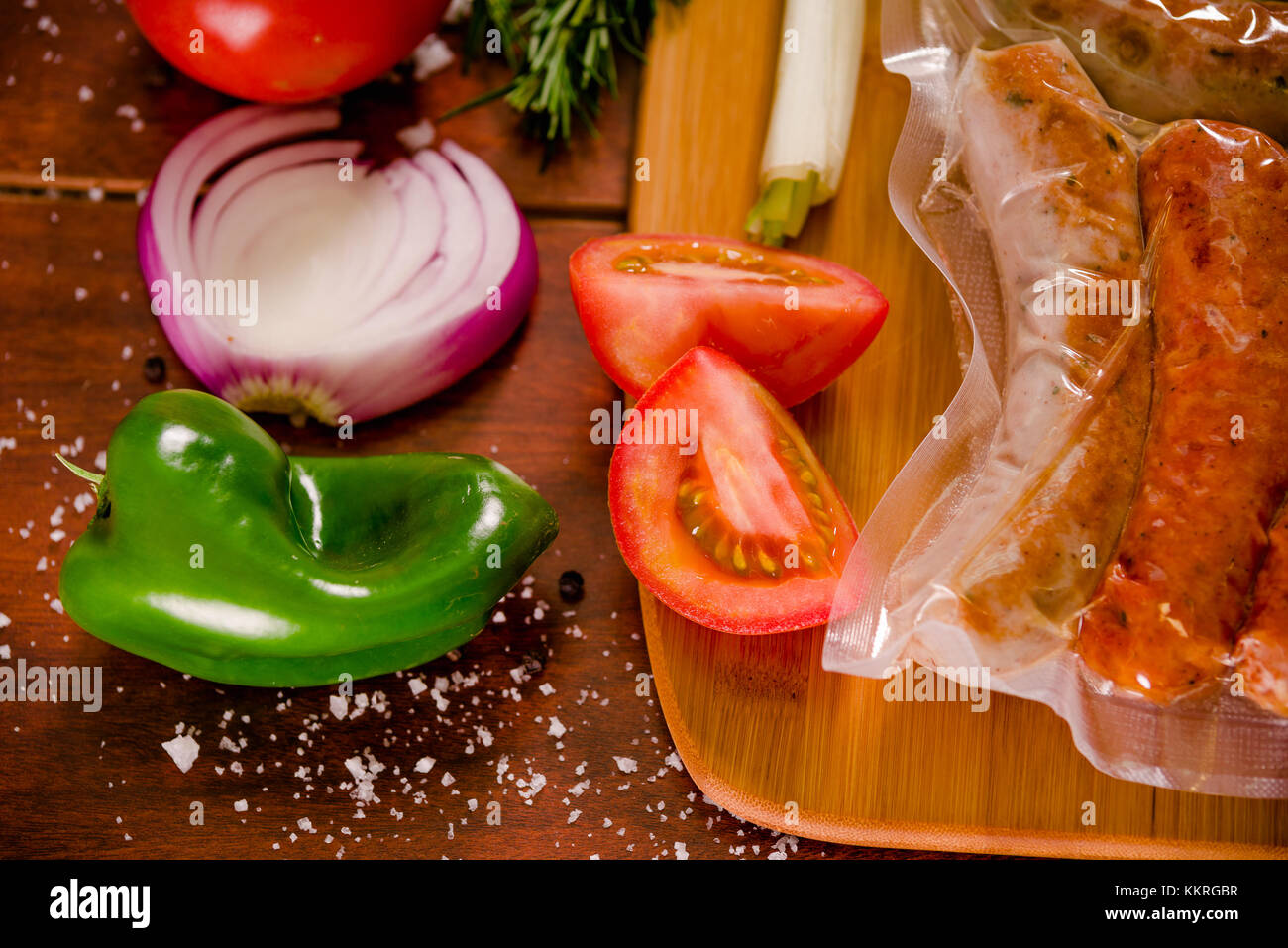 Above view of sausages inside of a plastic bags and vegetables, tomato ...