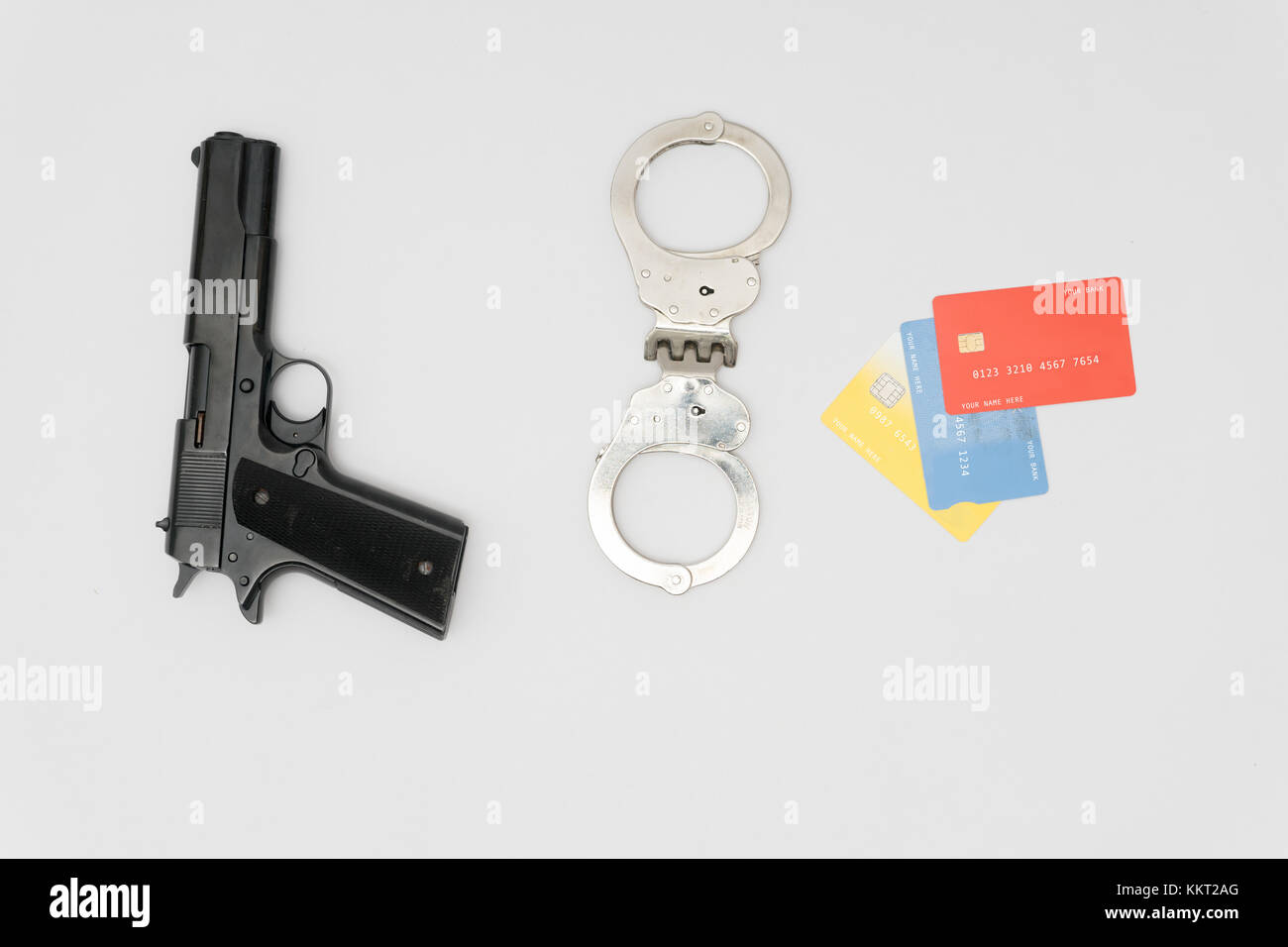 Handcuffs, gun and credit cards on white background Stock Photo - Alamy