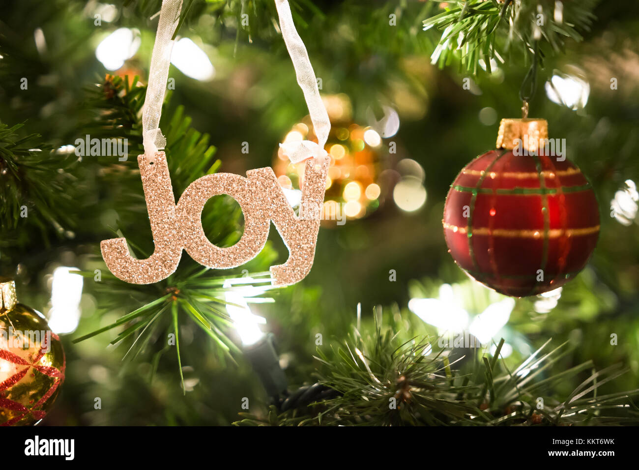 Glittery Joy word hanging on Christmas Tree branch Stock Photo - Alamy