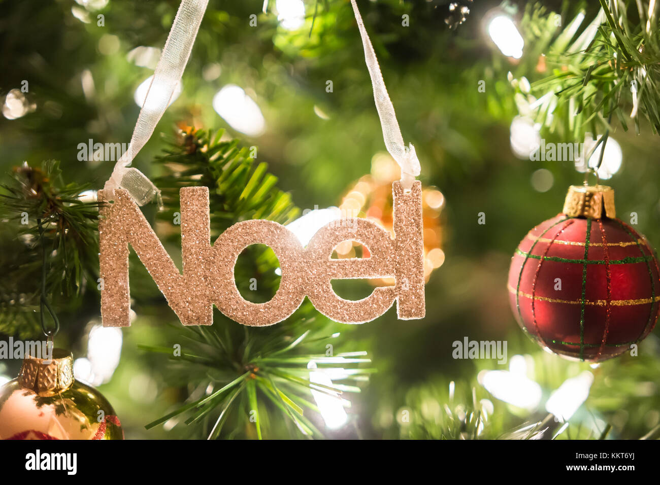 Glittery Noel word hanging on Christmas Tree branch Stock Photo - Alamy