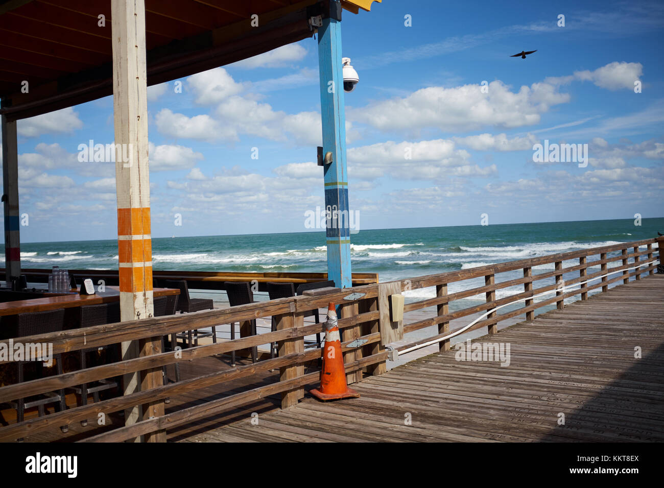 Wooden jetty or promenade alongside on open air restaurant on a patio ...