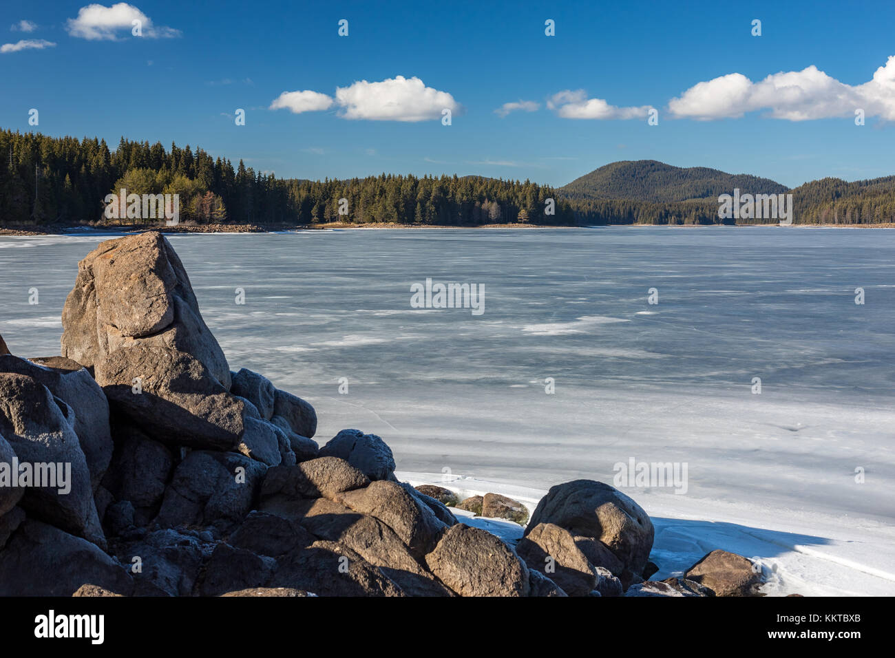 Beautiful rock formation, frozen lake water, white snow on the ice ...