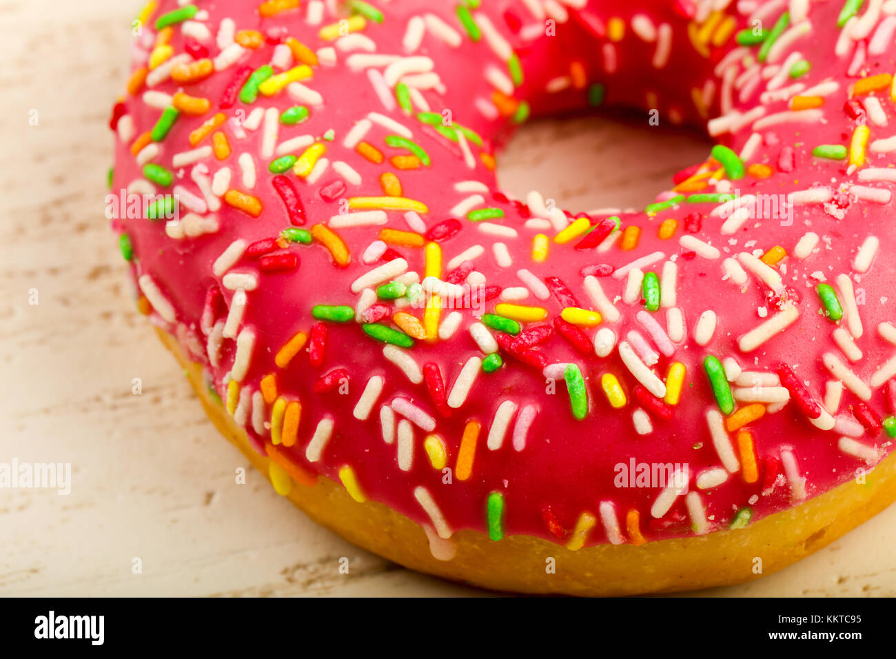 Pink Sweet iced donut over wooden background Stock Photo - Alamy