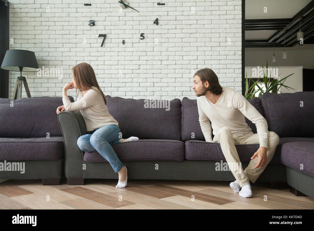 Young couple arguing sitting on sofa, man shouting at woman Stock Photo ...