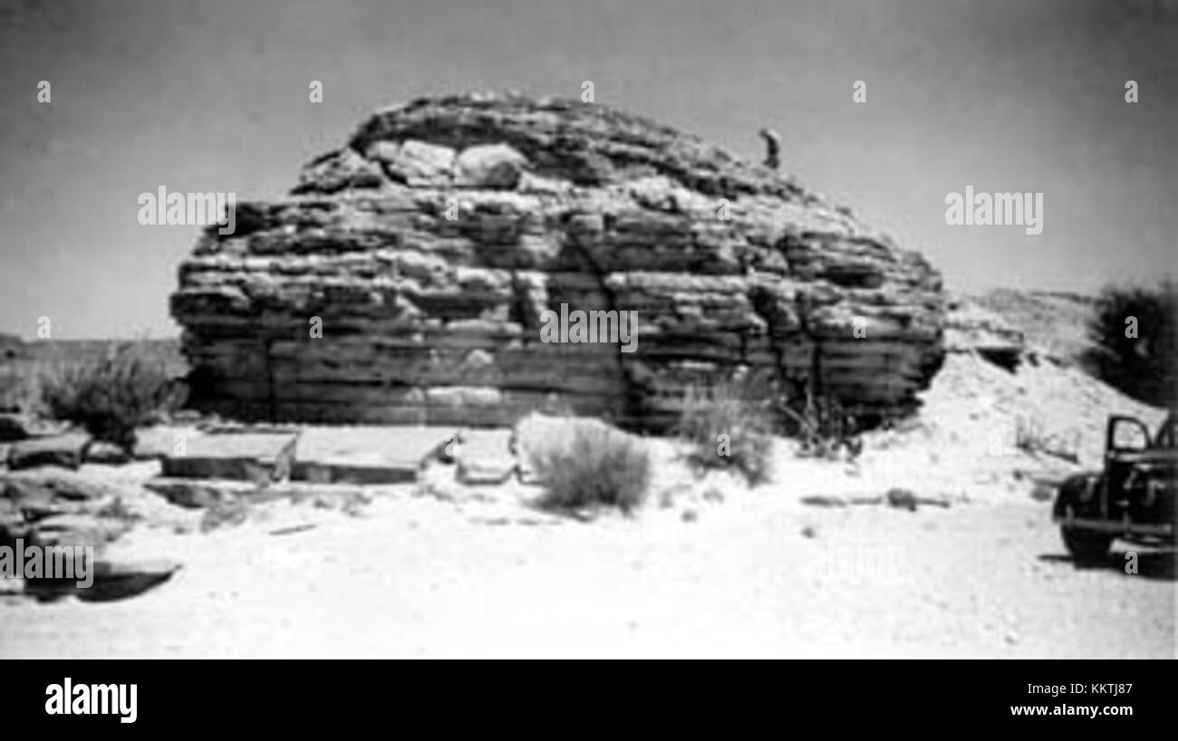 This photograph shows a large rock formation composed of layered ...