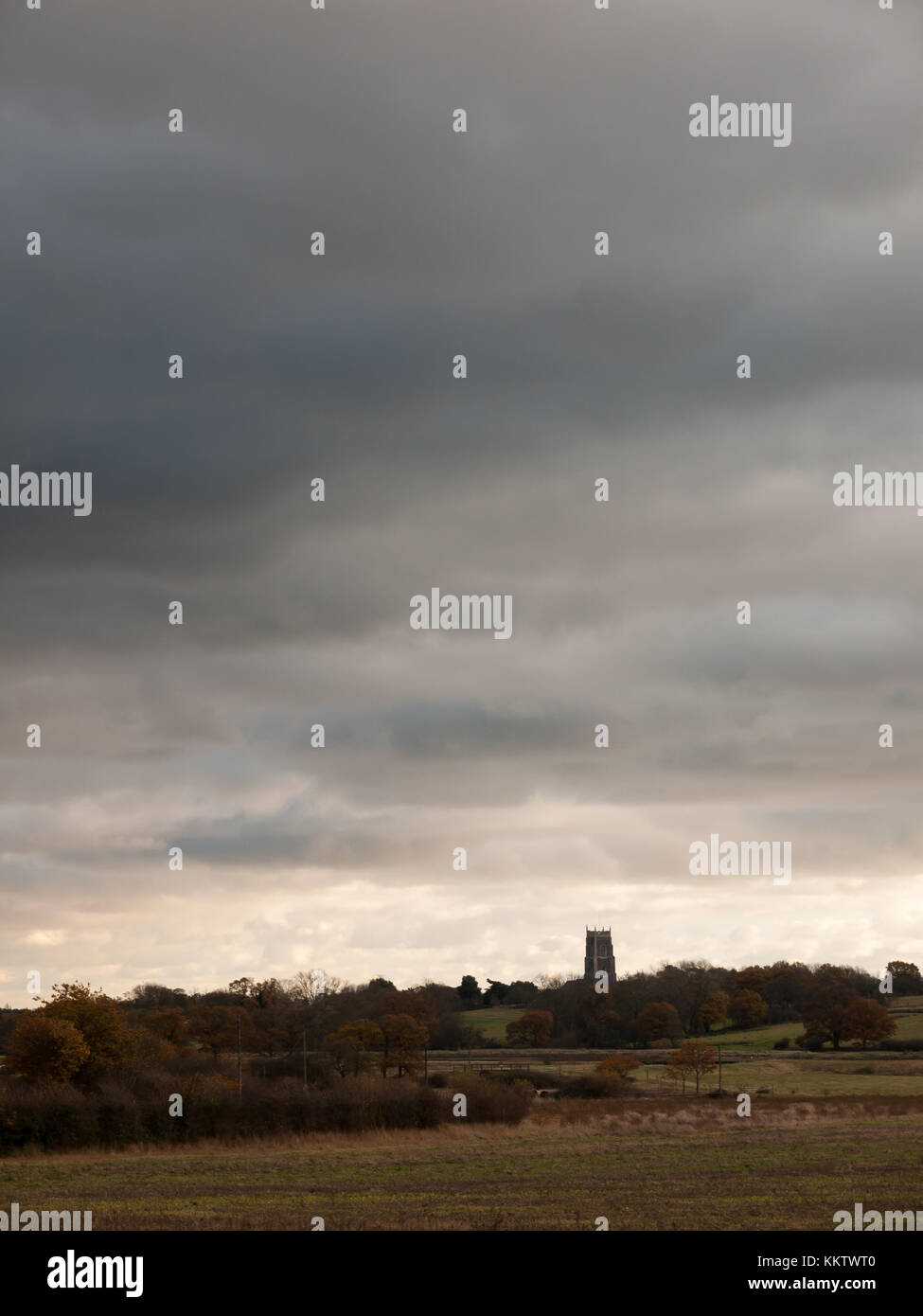 dramatic sky over open empty grassland plain special with church spire ...