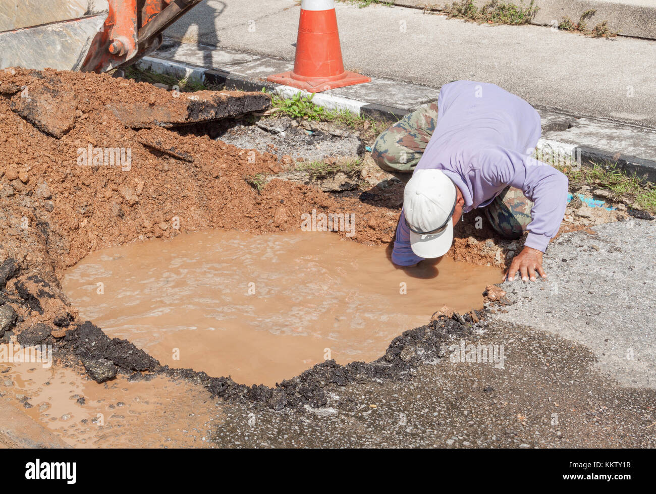 Plumbing Repair Man and excavator scoop digging, Worker using a small ...