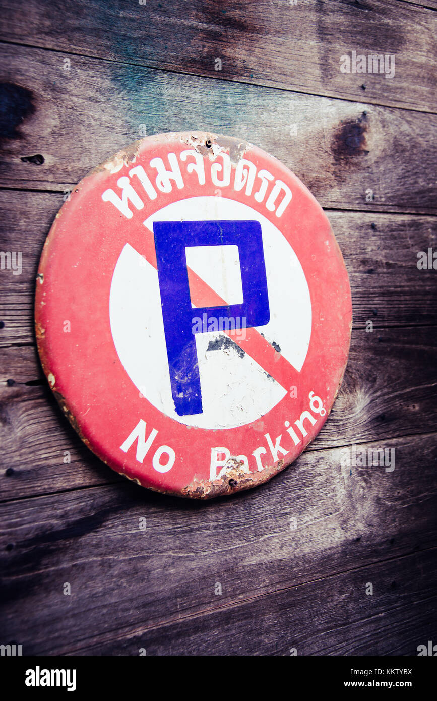 Rusty steel no parking sign in Thai language attached on classic wooden ...