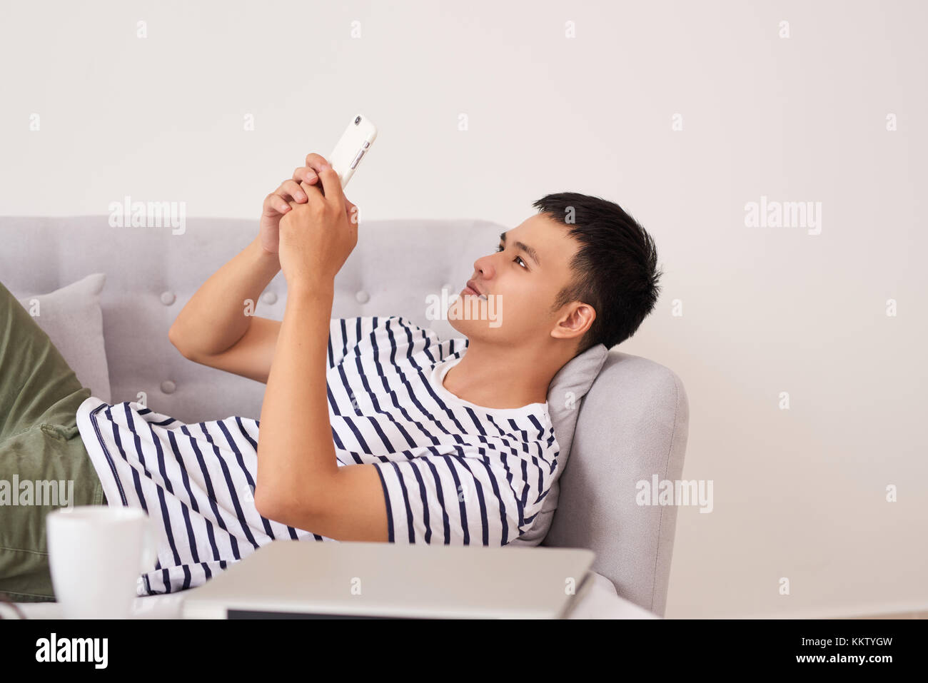 Man lying on couch smartphone hi-res stock photography and images - Alamy
