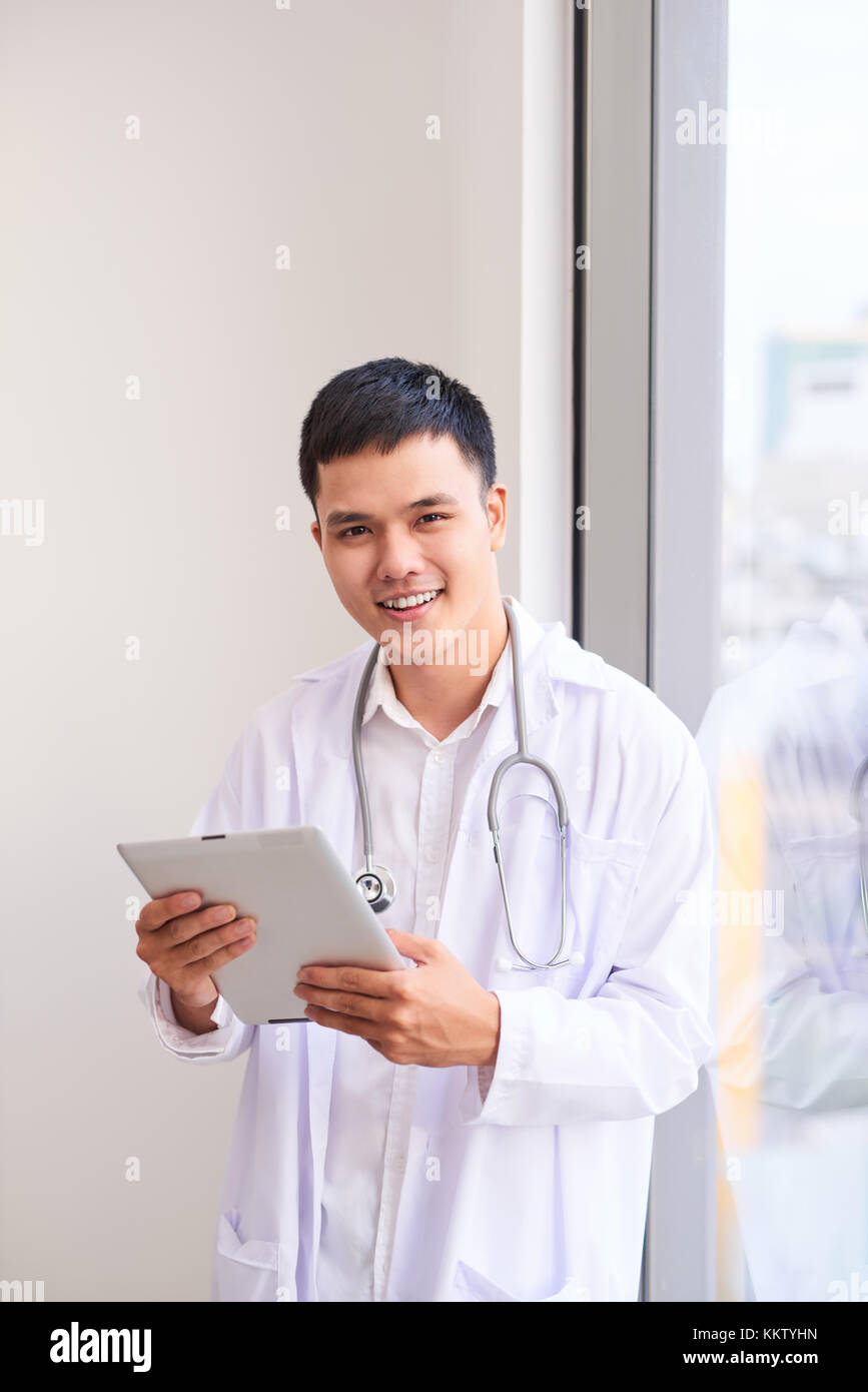 Young asian doctor using his tablet computer at work Stock Photo - Alamy
