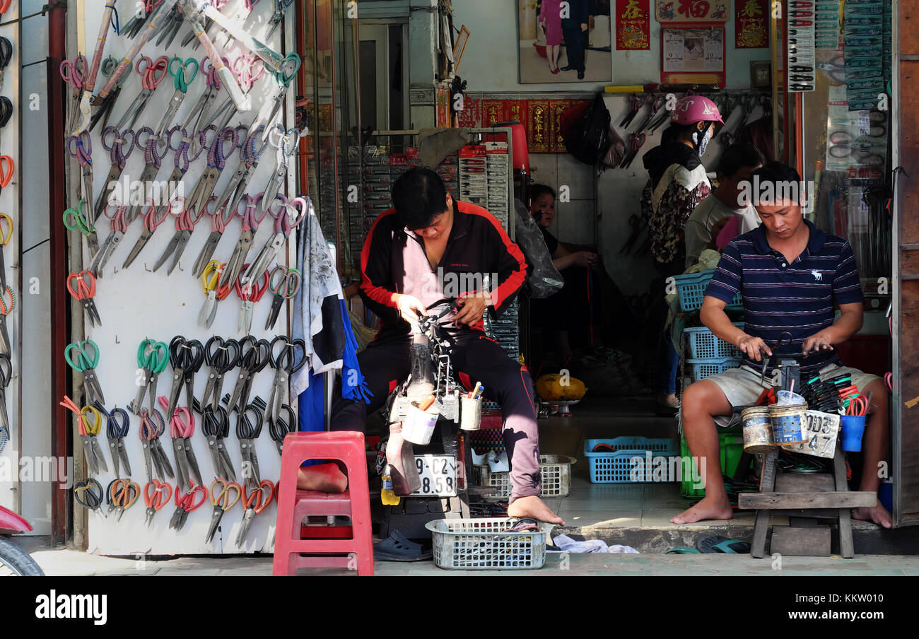 HO CHI MINH CITy, Man working at front of scissors shop at Cho Lon ...