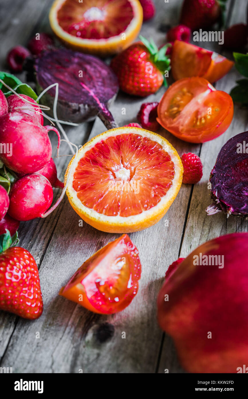 Red fruits and vegetables on wooden background Stock Photo - Alamy