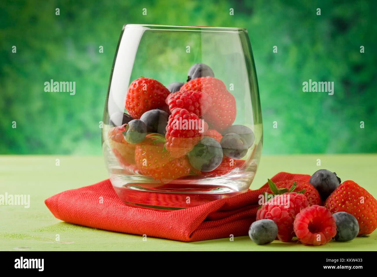 photo of delicious berries inside a crystal glass in front of green ...