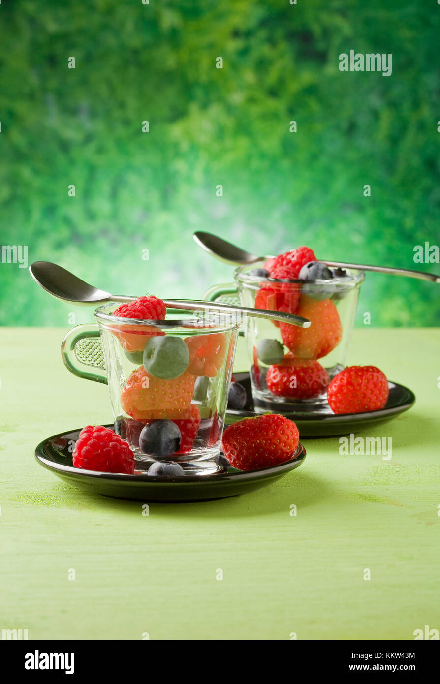 photo of delicious berries inside a glass cup with green background ...
