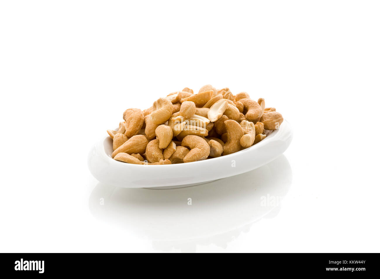 photo of delicious cashews inside a plate on white isoalted background ...