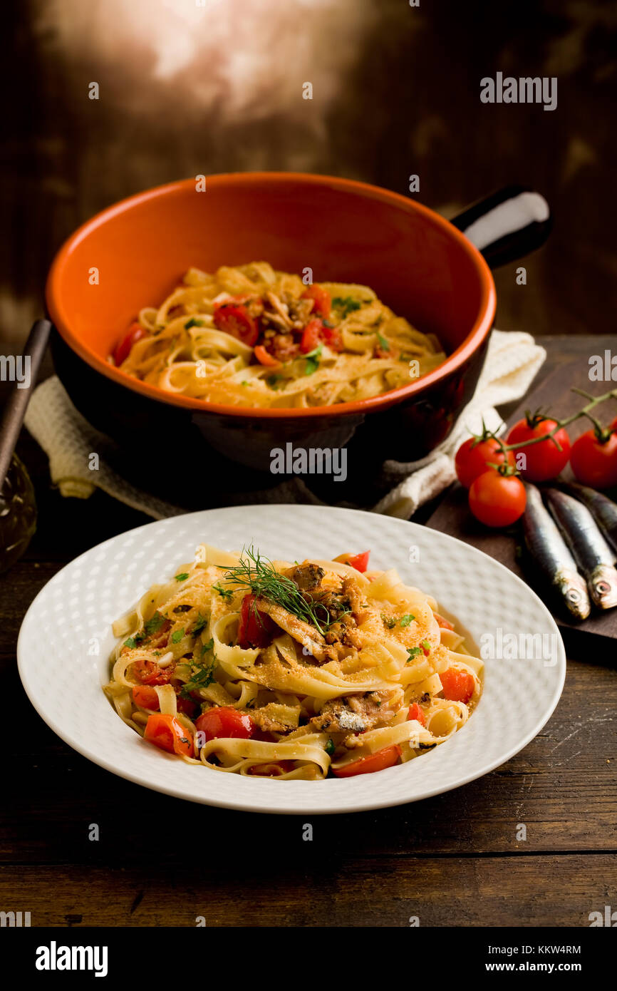 Italian regional dish made of pasta with sardines on wooden table Stock ...