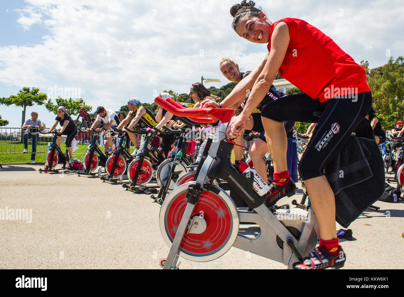People who are riding on an exercise bike in a public urban park in ...