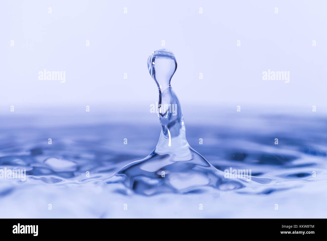 Close up of water drop dropping into water Stock Photo - Alamy