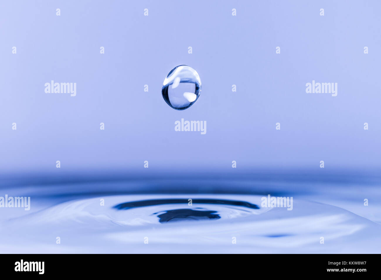 Close up of water drop dropping into water Stock Photo - Alamy