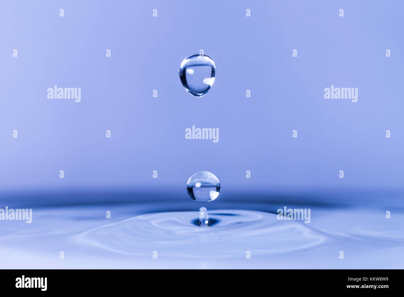 Close up of water drop dropping into water Stock Photo - Alamy