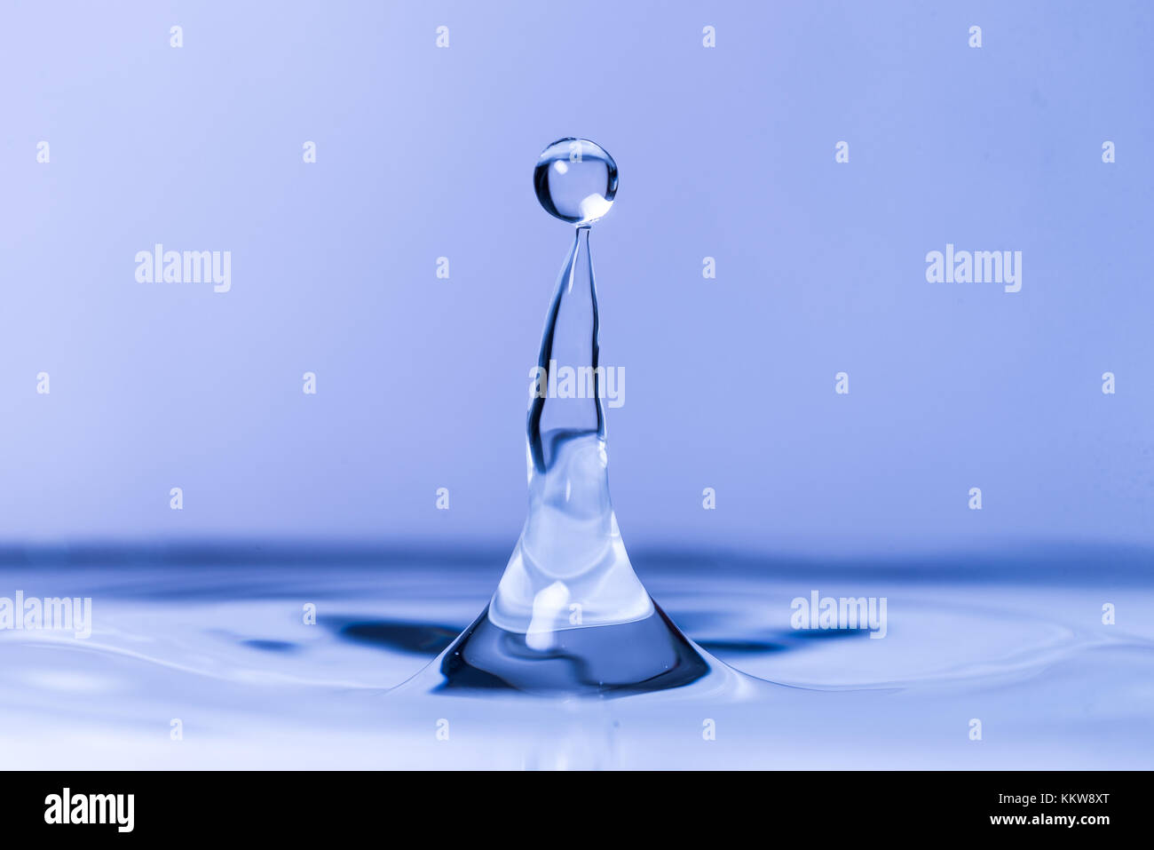 Close up of water drop dropping into water Stock Photo - Alamy