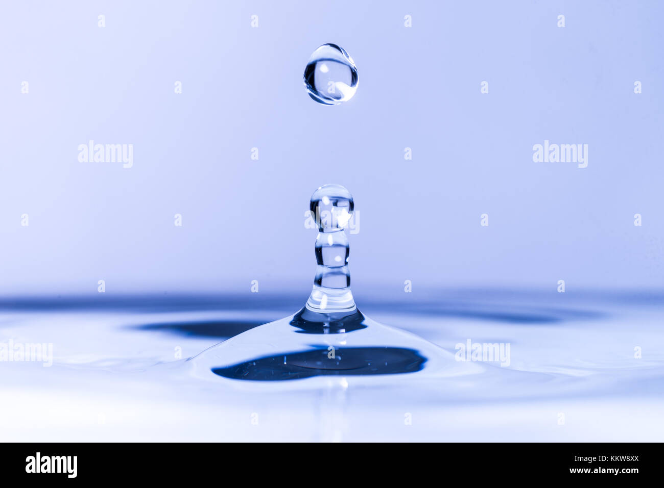 Close up of water drop dropping into water Stock Photo - Alamy