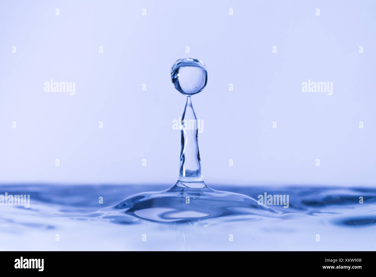 Close up of water drop dropping into water Stock Photo - Alamy