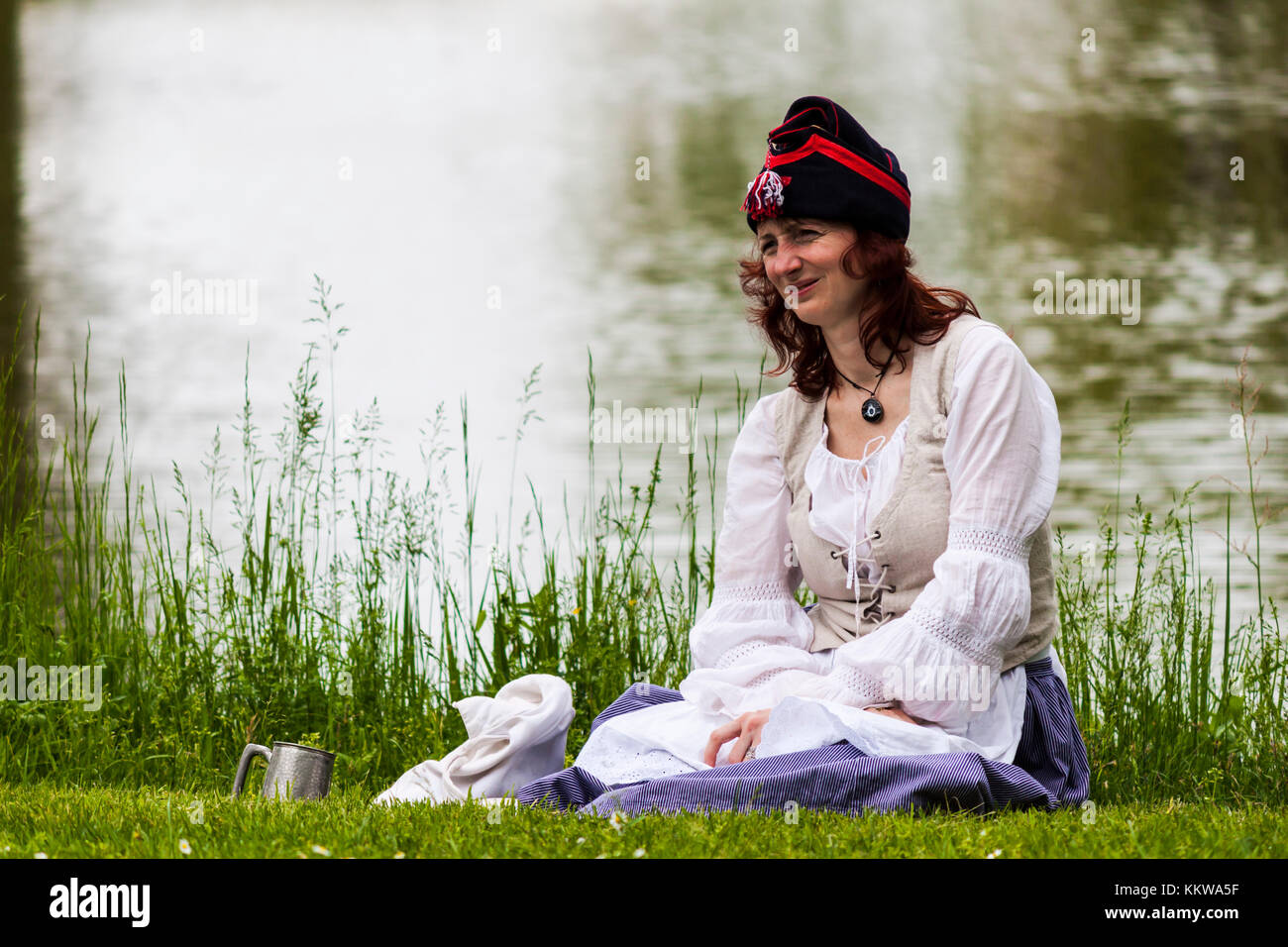 Woman of the napoleonic period sitting on the grass Stock Photo - Alamy