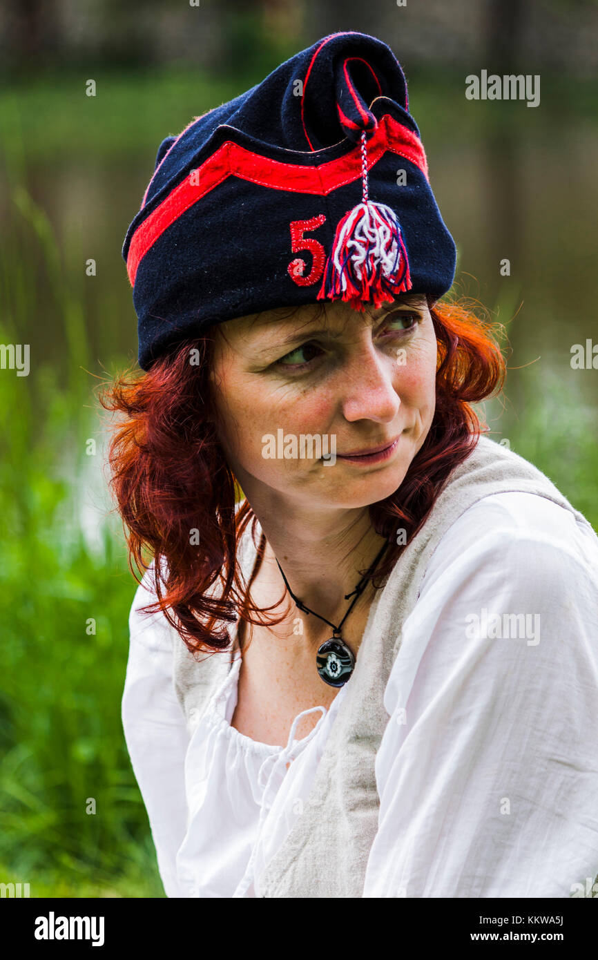 Woman of the napoleonic period sitting on the grass with worried facial ...
