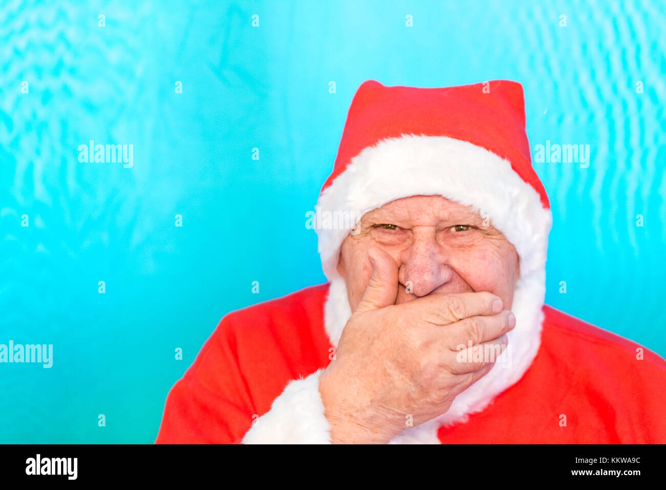 old man wearing Santa Claus costume covering his mouth with hand Stock ...