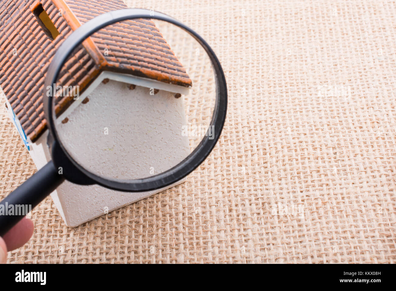 Little model house on behind a magnifying glass Stock Photo - Alamy