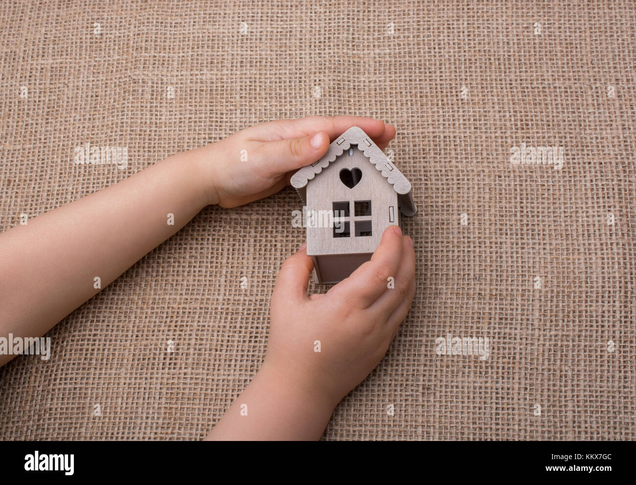 Child holding a model house on a linen canvas Stock Photo - Alamy