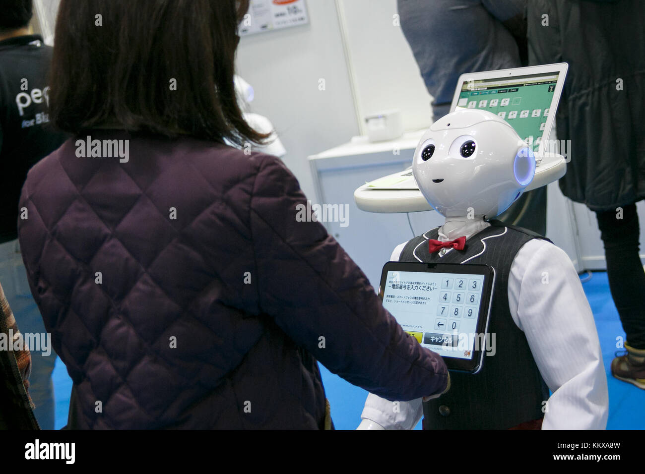 Tokyo, Japan. 2nd Dec, 2017. A woman tests a SoftBank's humanoid robot ...