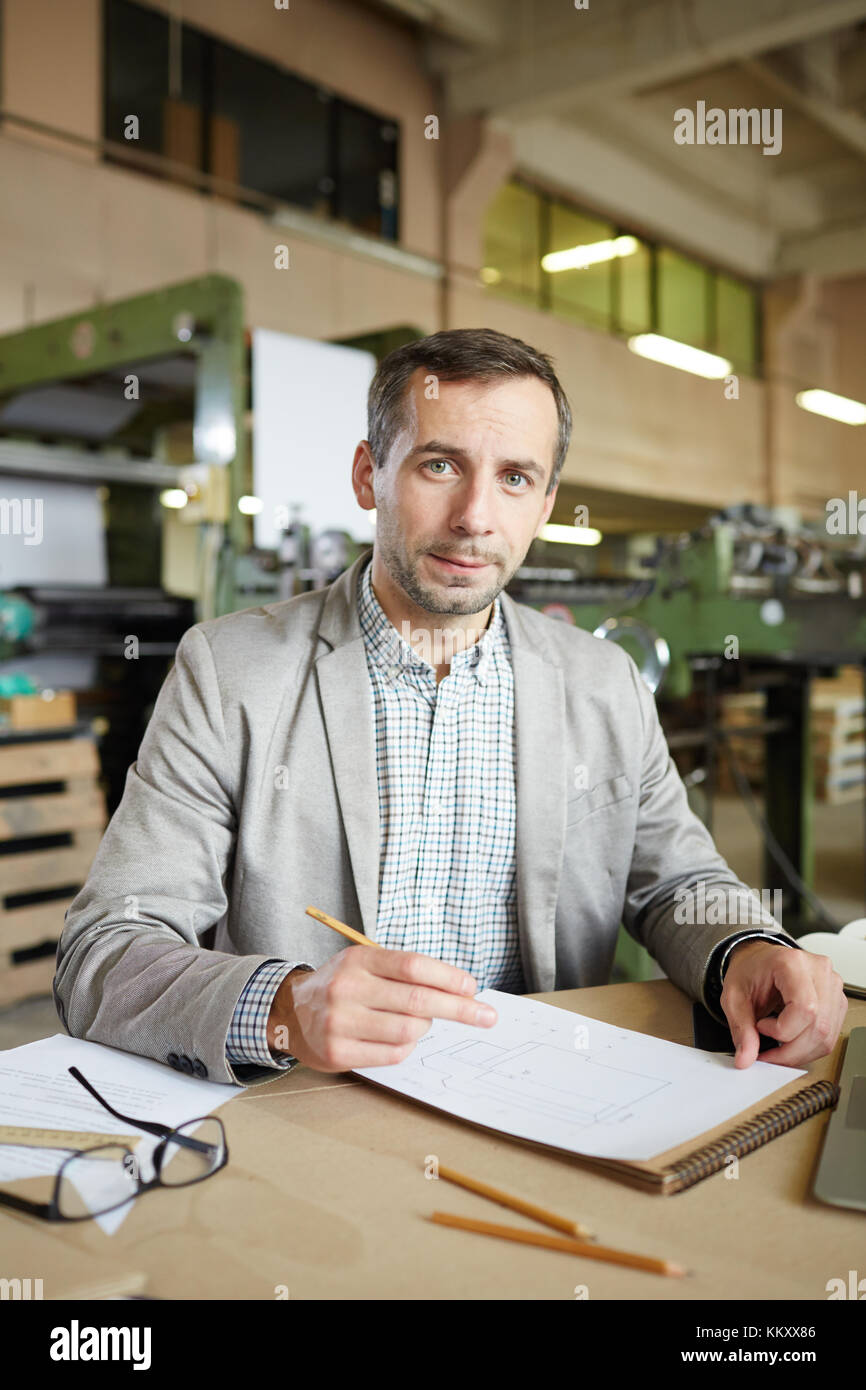 Contemporary engineer making sketches in notepad by workplace Stock ...