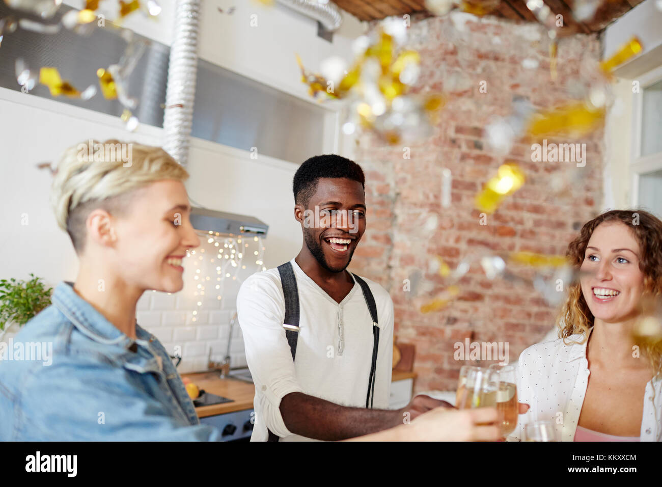 Intercultural group of young friends clinking with flutes of champagne ...