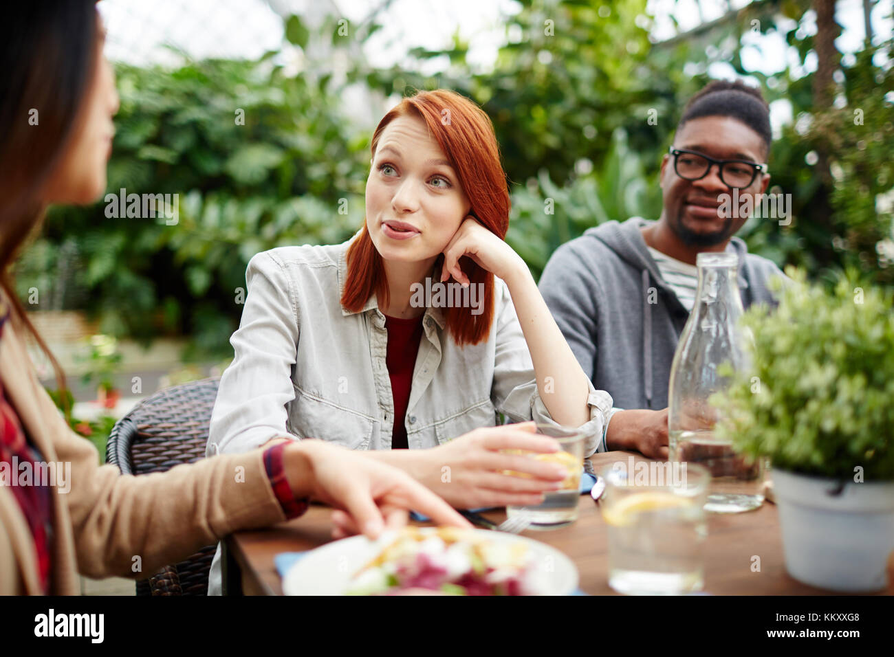 Group of intercultural young companions gathered by breakfast outdoors ...