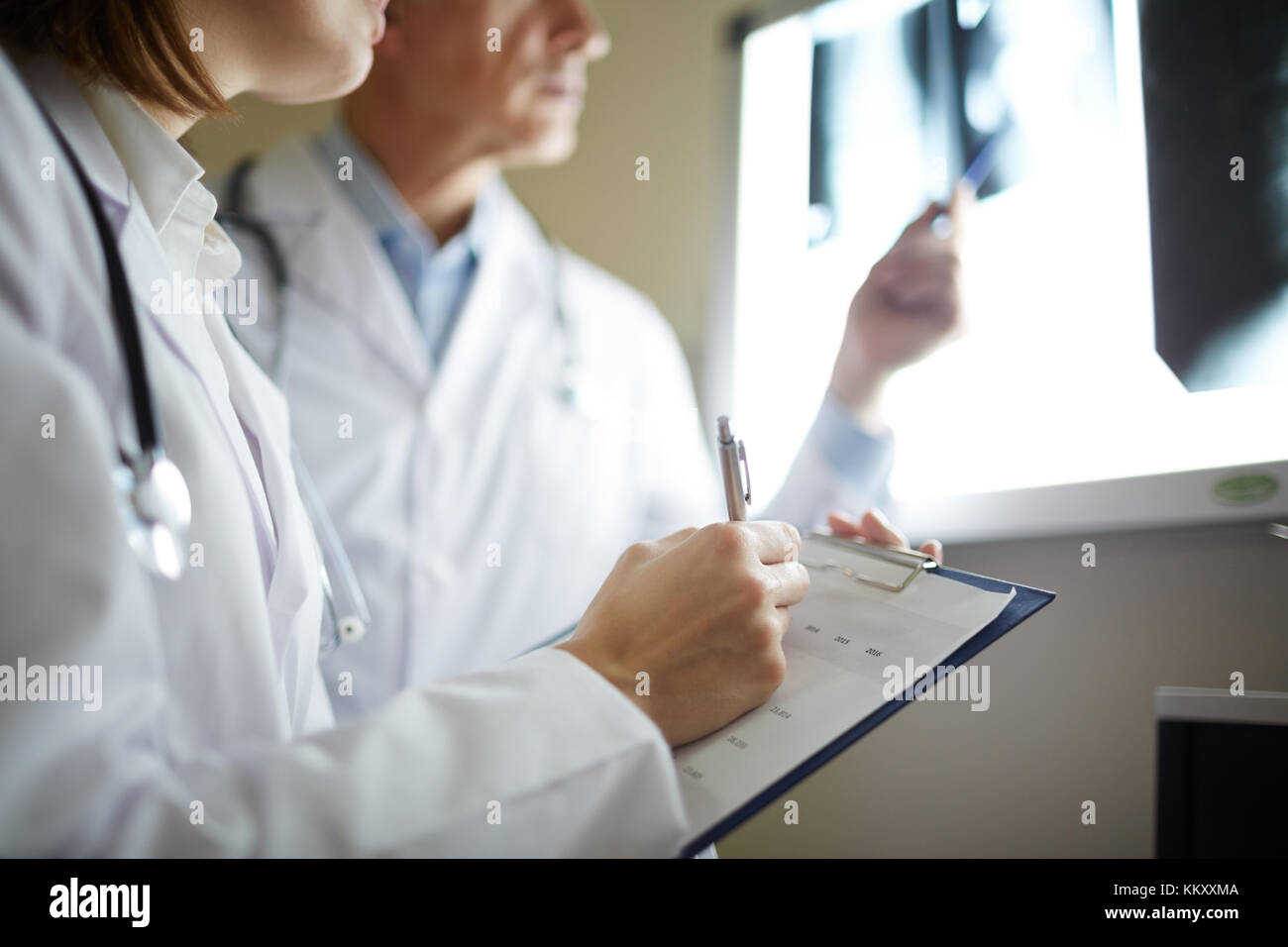 One of radiologists making notes in medical form while analyzing x-ray ...