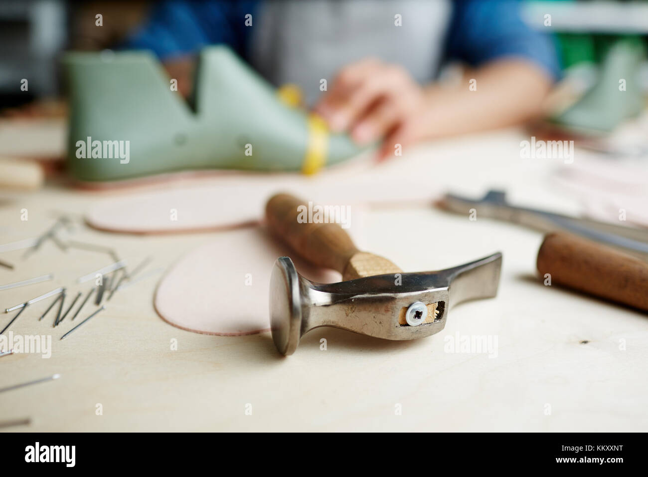 Hammer of shoemaker on workplace with cobbler working on background ...