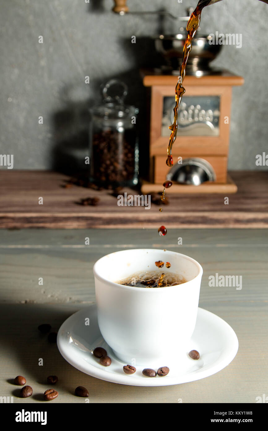 Pouring a Cup of Coffee Creating Splash on Wooden Background Stock ...