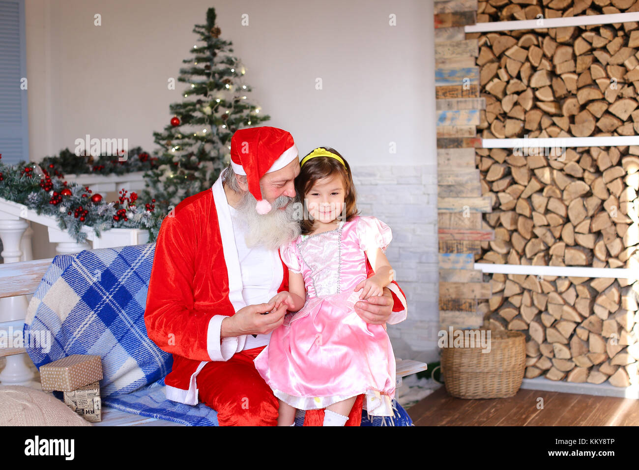 Father Christmas speaking with pretty girl dressed in pink frock and ...