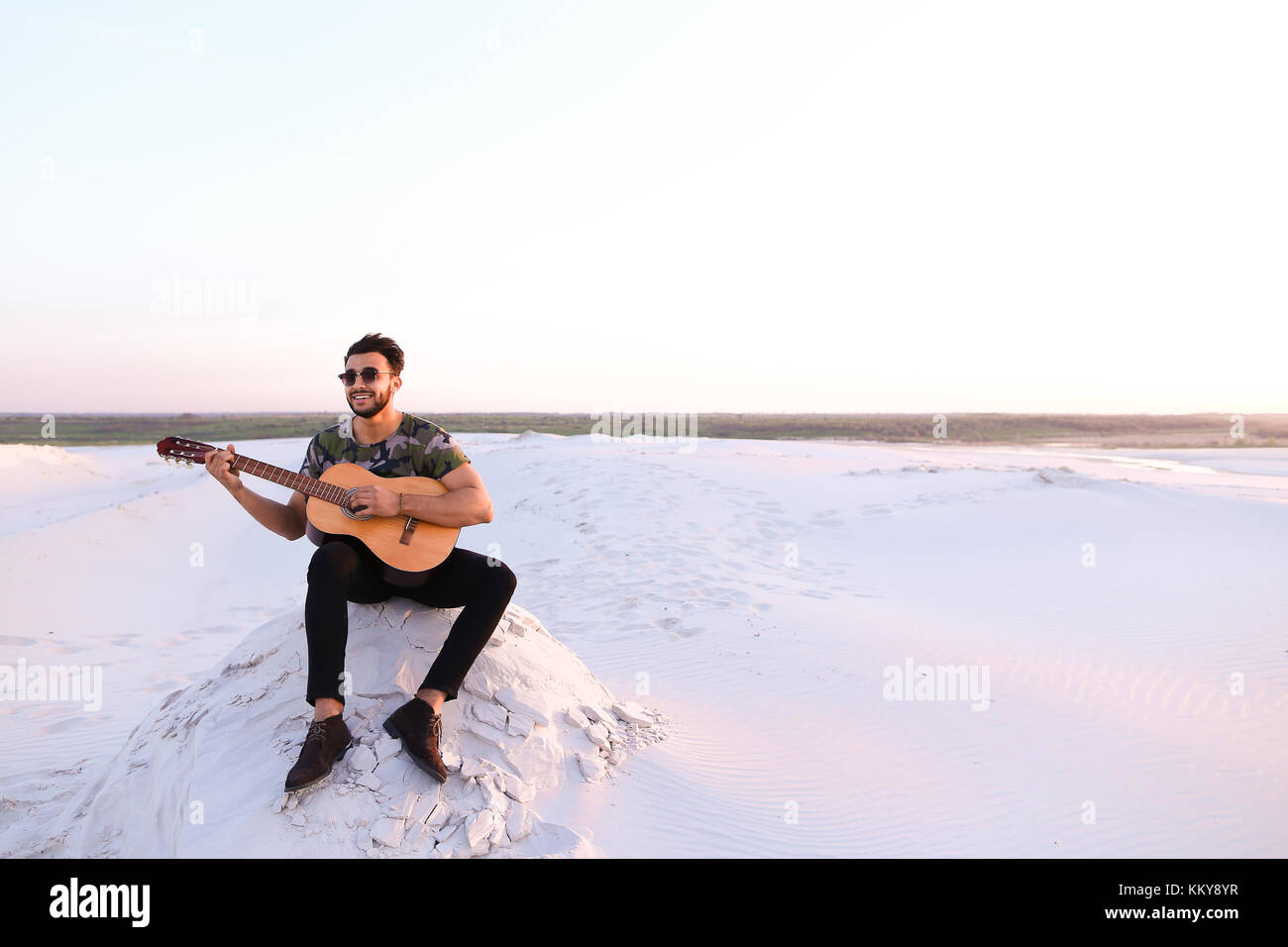 Handsome guy, Arab playing with pleasure on musical stringed instrument ...