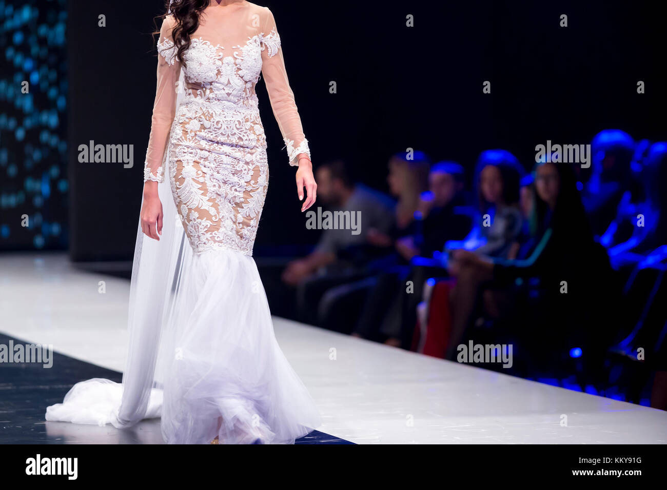 Female model walks the runway in white dress during a Fashion Show ...